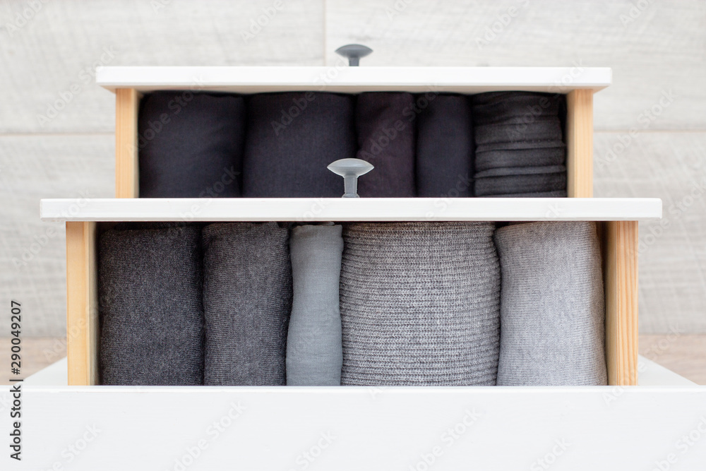 two open drawers with women's clothing in black and different shades of ...