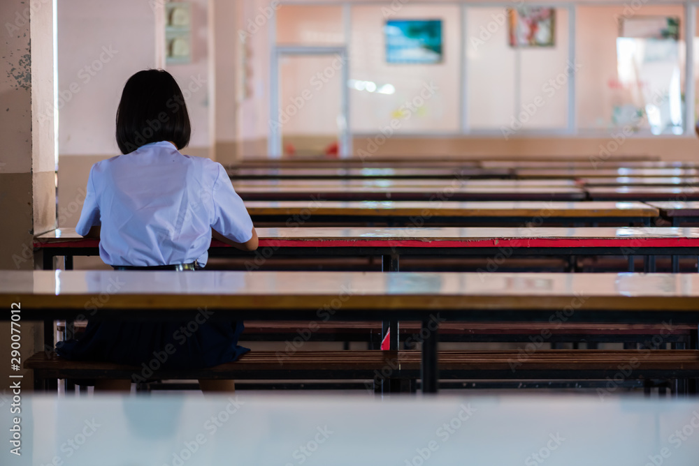 Thai female high school student is sitting alone in the school ...