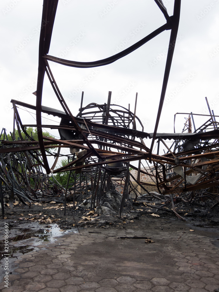 Twisted steel beams after a factory fire. Warehouse destroyed by fire ...