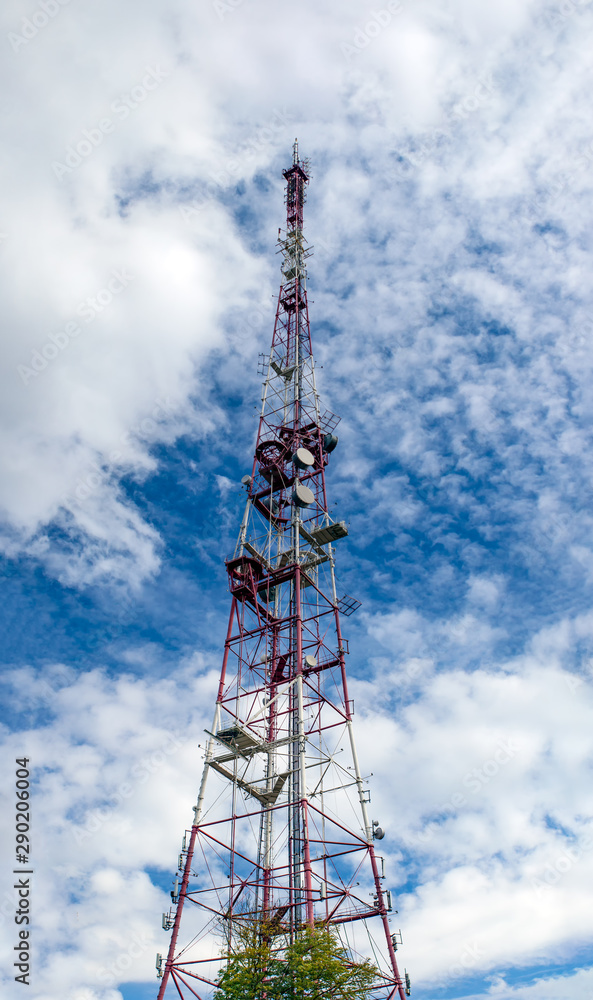 Telecommunication tower with a lot of antennas against blue sky with ...