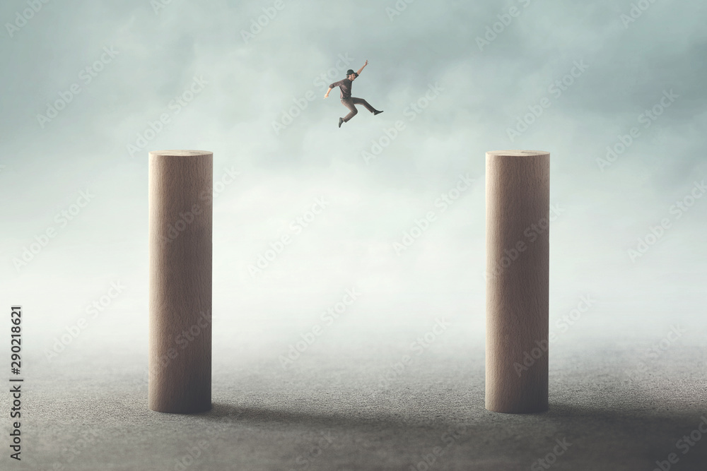 man trying to reach the tower with a big jump Stock Photo | Adobe Stock