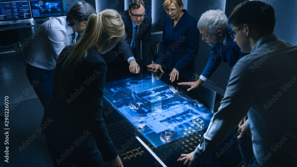 Team of Government Intelligence / FBI Agents Standing Around Digital ...