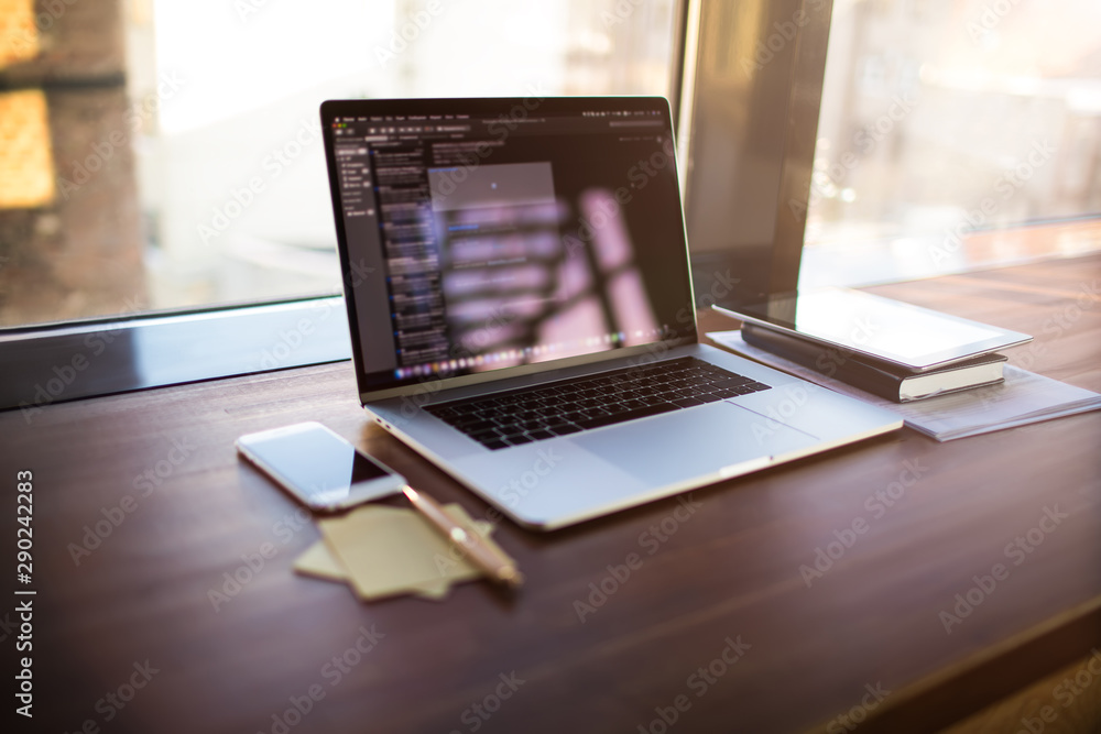 Workstation with open pc laptop computer, mobile phone and touch pad in ...