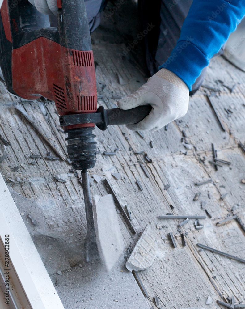 construction worker using a handheld demolition hammer and wall breaker ...