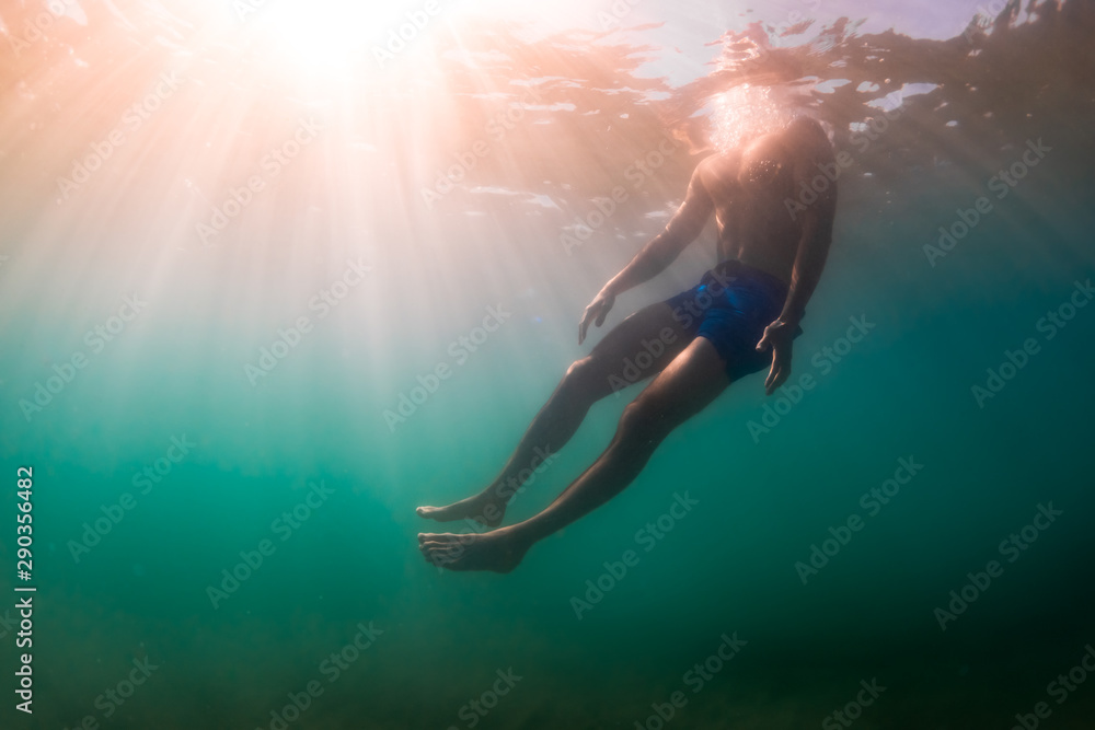 Man rises to surface of water while diving in sunlight dappled u Stock ...