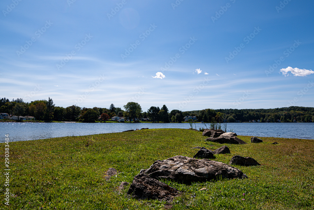 Ground level line of rocks on a peninsula jutting out into a lake with ...