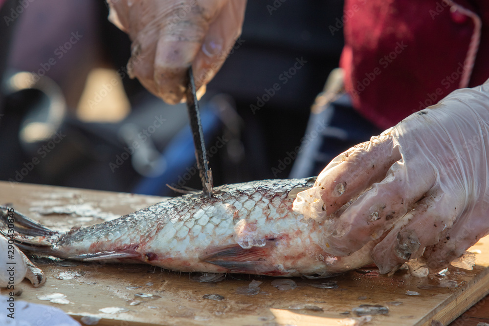 On the table, clean the fish from the scales and remove the entrails ...