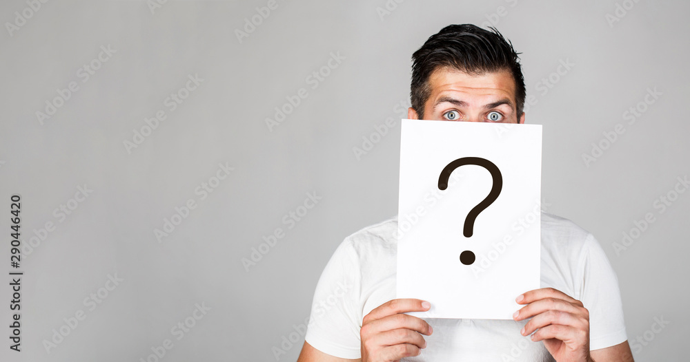 Portrait of man, peeking behind of interrogation symbol. Question mark ...