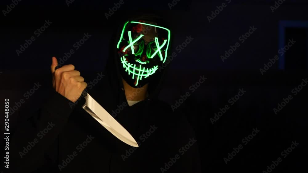 A scary slasher killer in a generic anonymous halloween horror mask ...