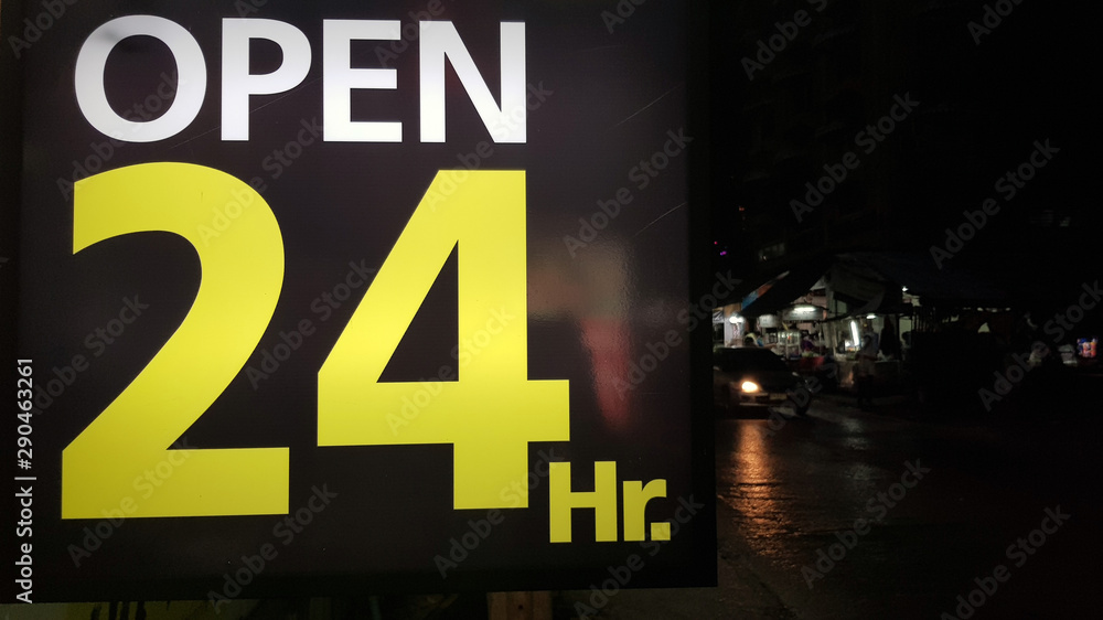 Open 24 hours label (tag),sign on the road side at night with blurred ...