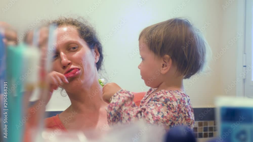 Mother teaching kid teeth brushing. Mother and daughter brushing teeth ...
