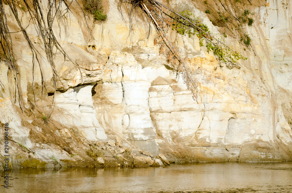 Clay cliff near the water of the river with erosional types of relief ...