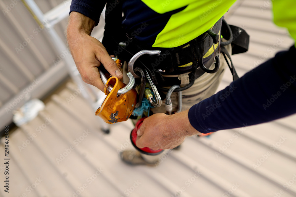 Industrial rope access technician hand clipping secondary backup safety ...