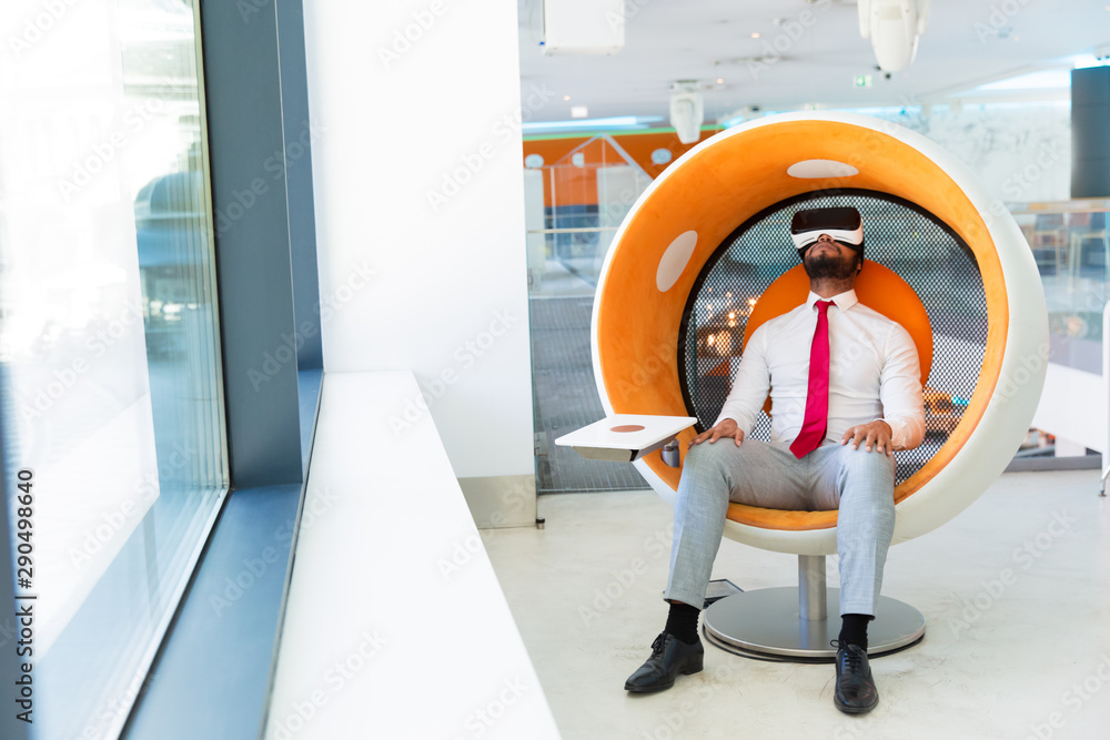Relaxed businessman enjoying virtual video in modern office lounge. Man ...