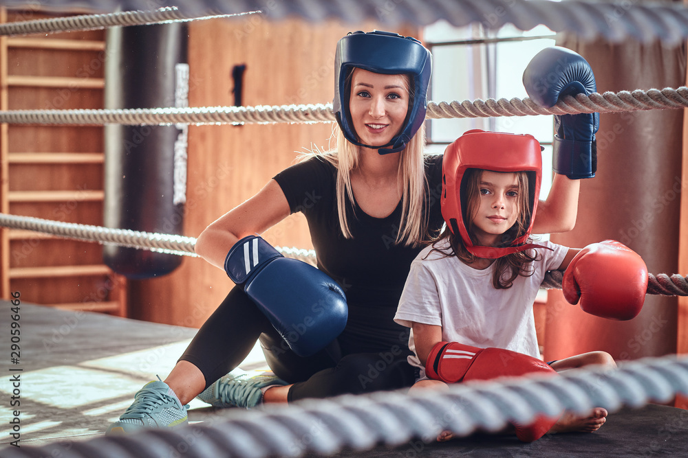 Young cute girl in helmet and her beautiful female boxing trainer are ...