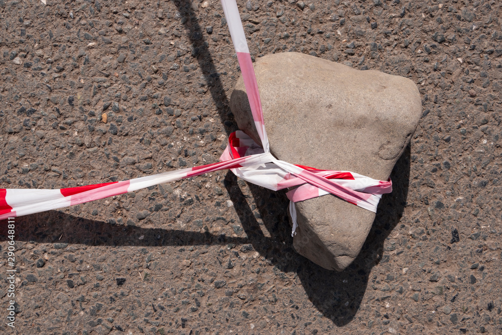 Stone is tied with a police tape, the colors are red and white ...
