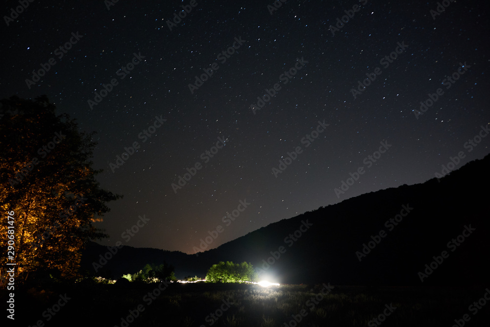 Night starry sky over the mountains. Stars and constellations are ...