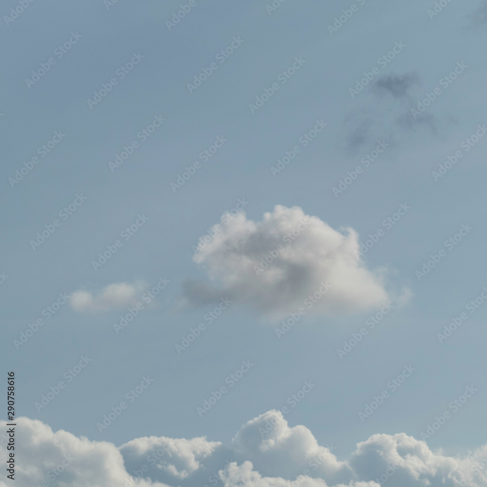 One fluffy cloud floating above other clouds. Dreamy background for ...