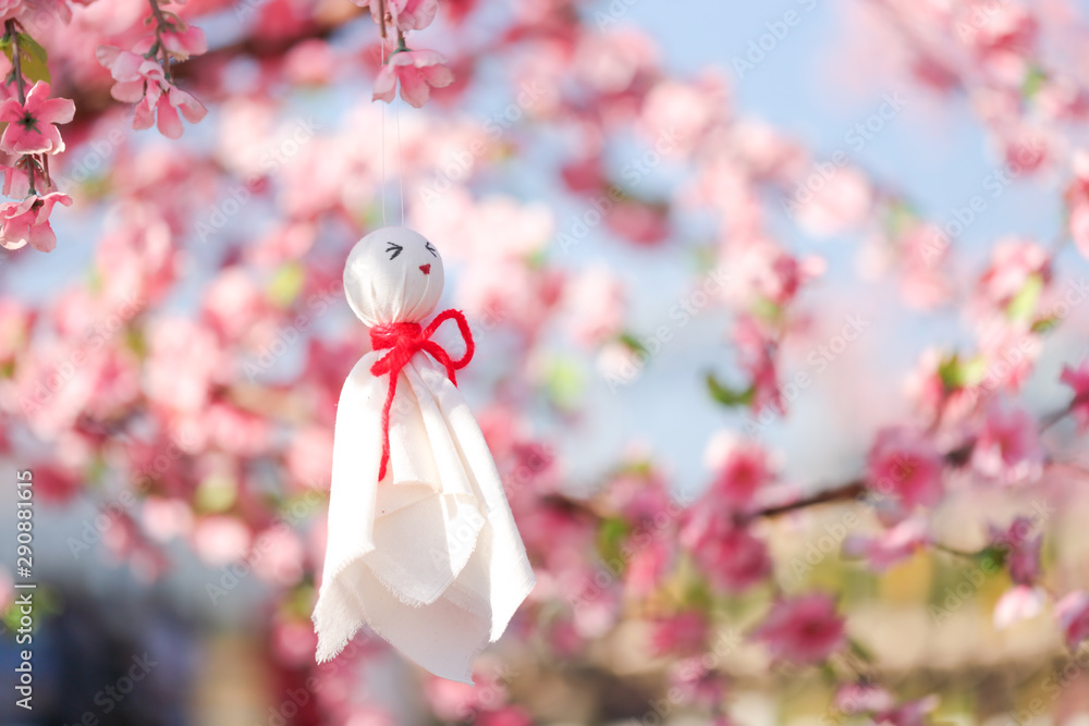 Rain doll, white cloth japanese doll hanged under pink flower tree or ...