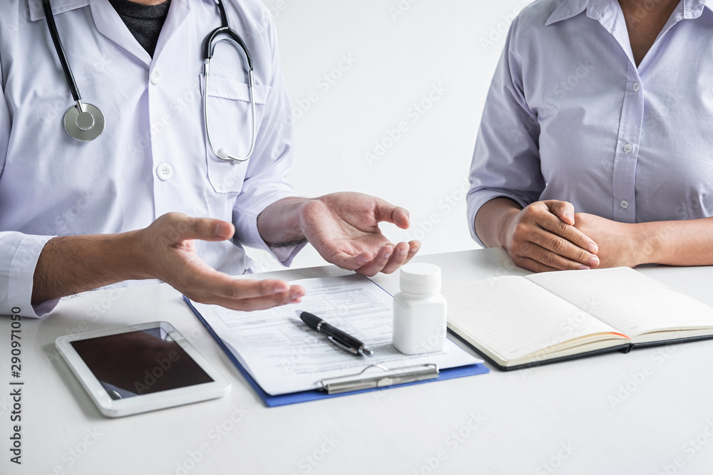 Doctor consulting with patient and checking sickness condition while ...