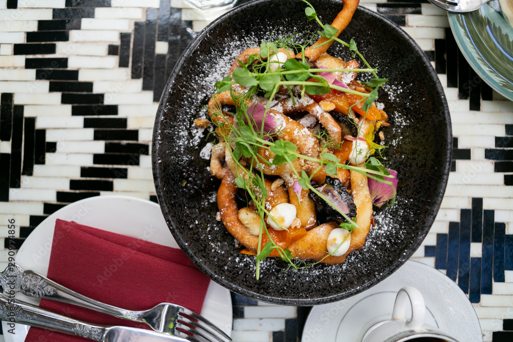 Fancy funnel cake with goat cheese, powdered sugar, edible flowers, and ...
