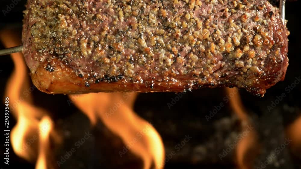 Vidéo Stock A beef rump roast with a dry rub seasoning cooking over an ...