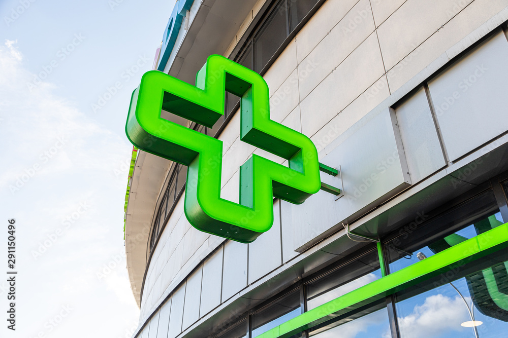 Close-up of green cross - sign of pharmacy on glass building Stock ...