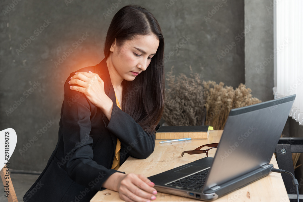 Image of young office woman shoulder pain while sitting at working desk ...