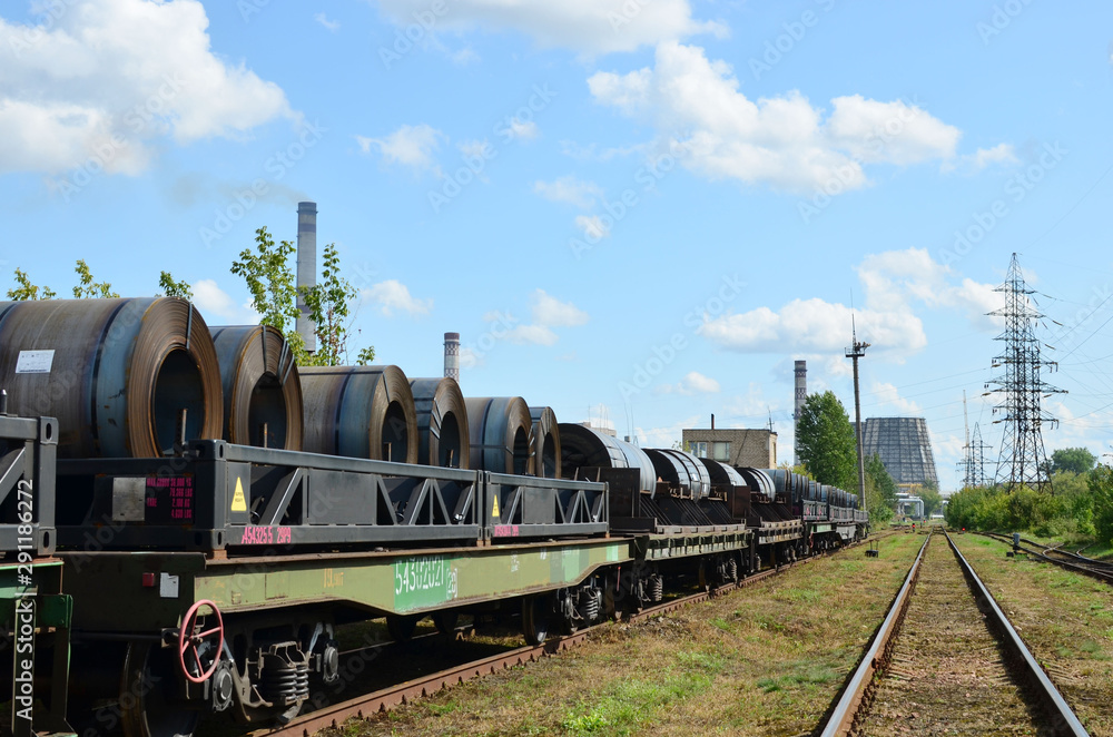 Rolled steel coil on on a freight train fixed by a chain. Import/export ...
