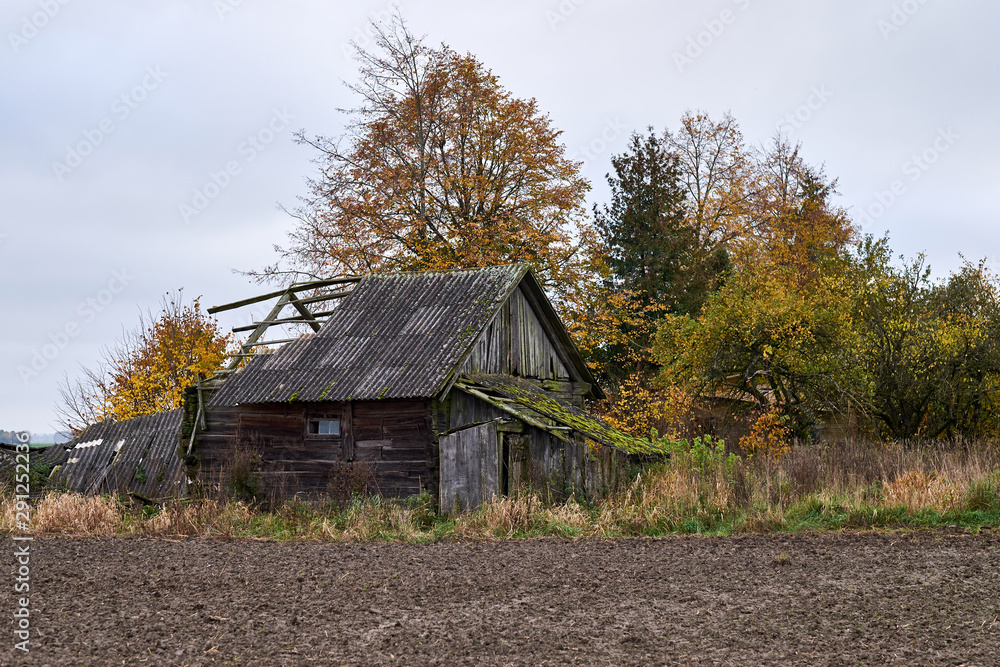 Old wooden abandoned farmstead in the middle of the field in Lithuania ...