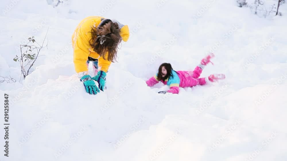 Preteen girls watches, unamused, as her little sister slides and ...