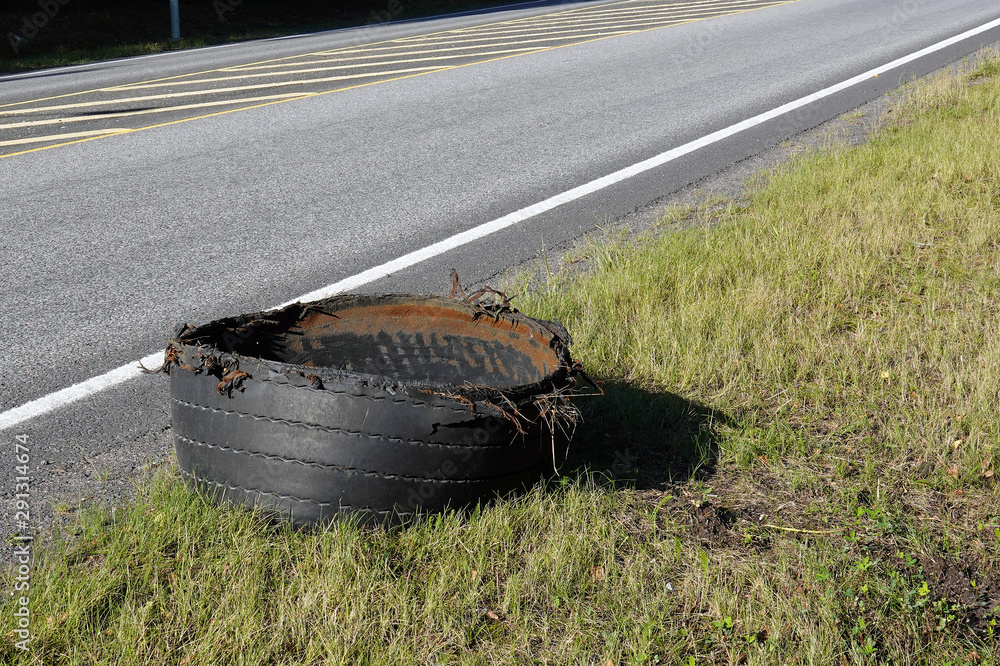 Exploded tire of semi truck on highway roadside. Stock Photo | Adobe Stock