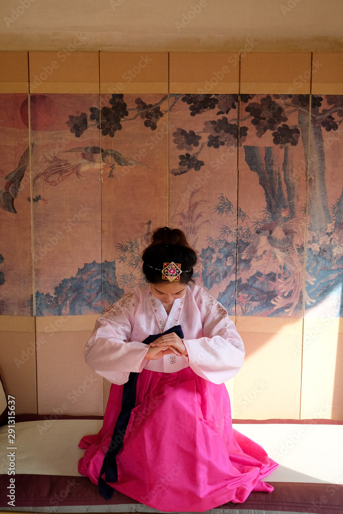 Korean girl acting respectful by join hands on her knee ,sitting,bend ...