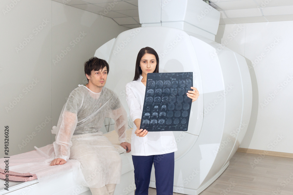 Confident pleasant female doctor working with MRI scan results and ...