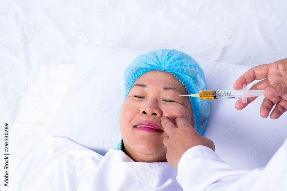 Older women treat skin conditions by injecting Botox on the face of the ...