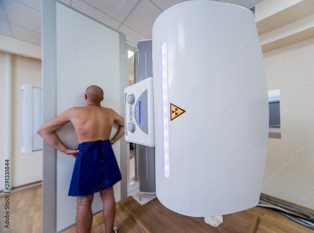 Radiologist and patient in a x-ray room. Classic ceiling-mounted x-ray ...