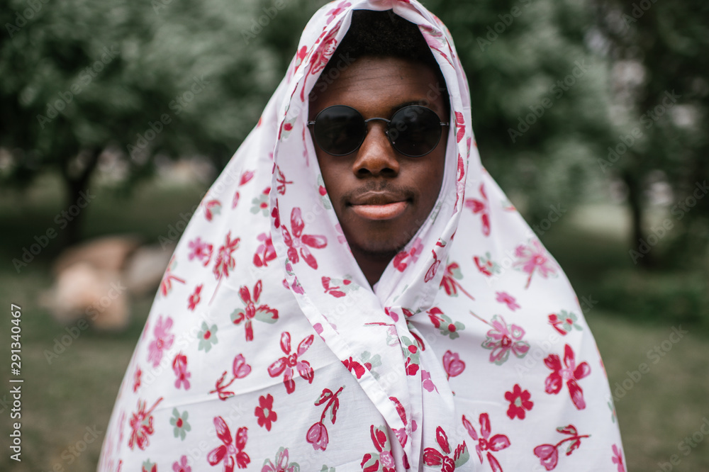 Dark skinned man covered in printed sheet like arabian sheikh. Closeup ...