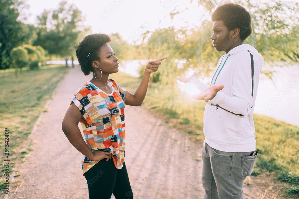 Serious African American girl blaming upset man, pointing finger at him ...