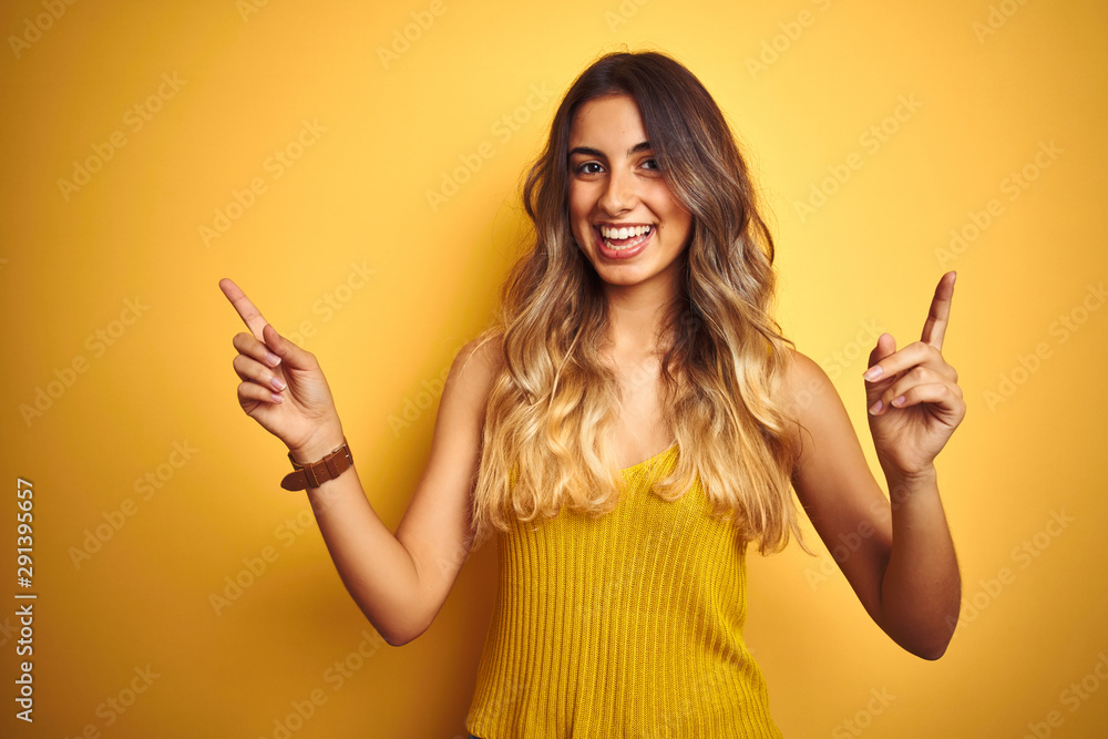 Young beautiful woman wearing t-shirt over yellow isolated background ...