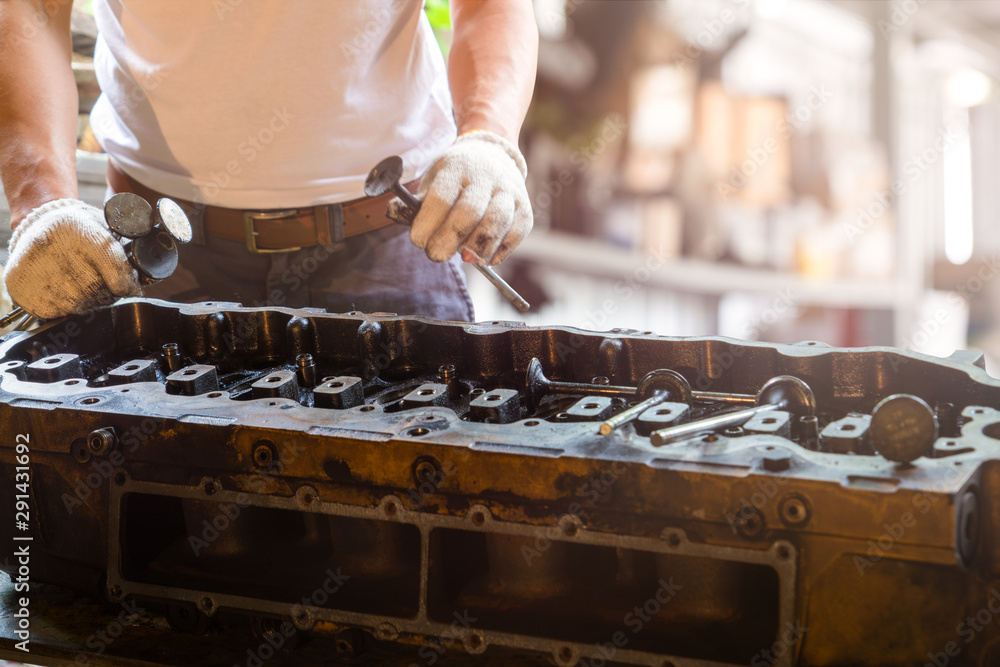 closed up of cylinder head and mechanic man holding valve and ...