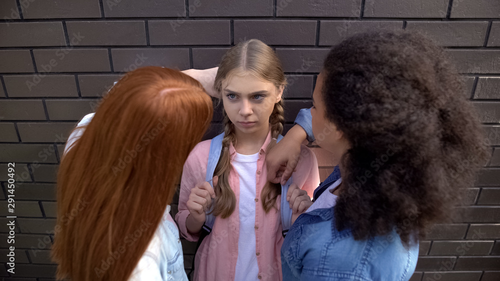 Cruel schoolgirls pushing younger teenager against wall, psychological ...