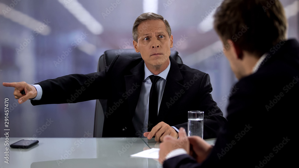 Angry male chief pointing exit to male candidate during job interview ...
