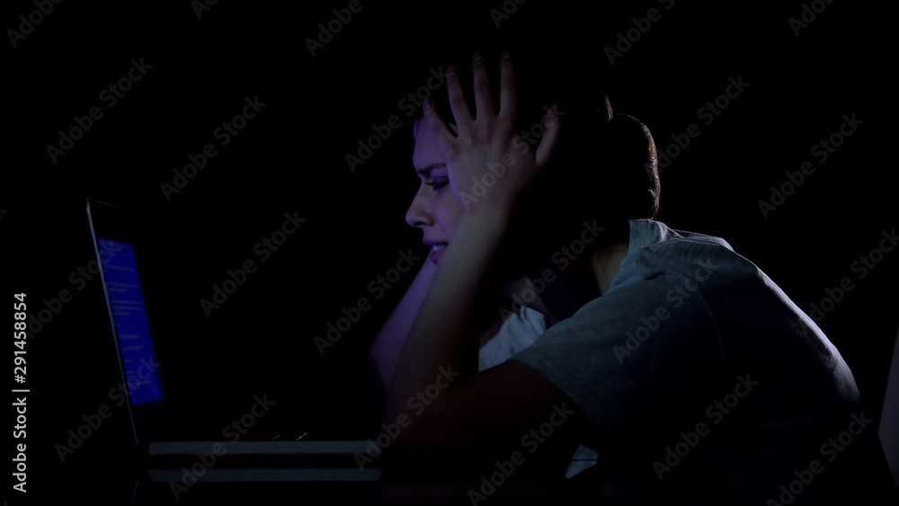 Desperate woman watching at blue screen of death on her laptop, virus ...
