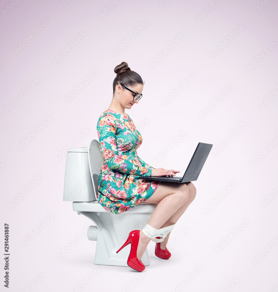 Young girl in glasses and flower dress uses a laptop while sitting in ...