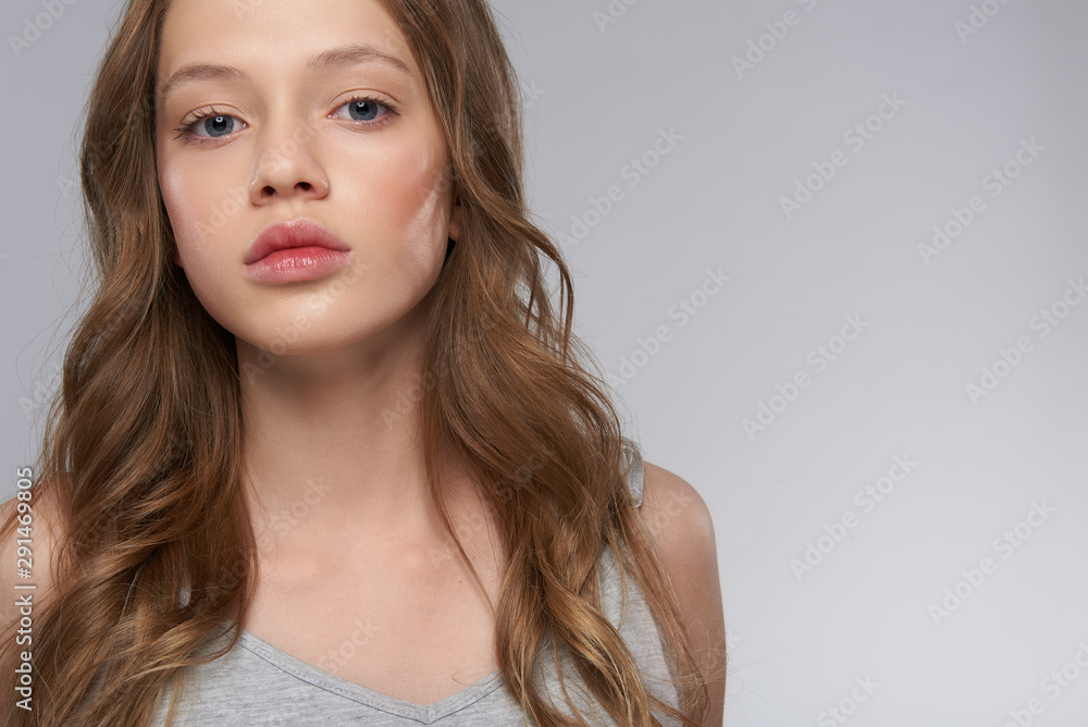 Beautiful teen girl with long brown hair posing against gray-white background Stock Photo ...