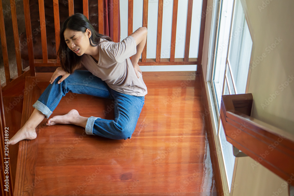 injured woman with back pain or injury; portrait of asian woman falling ...