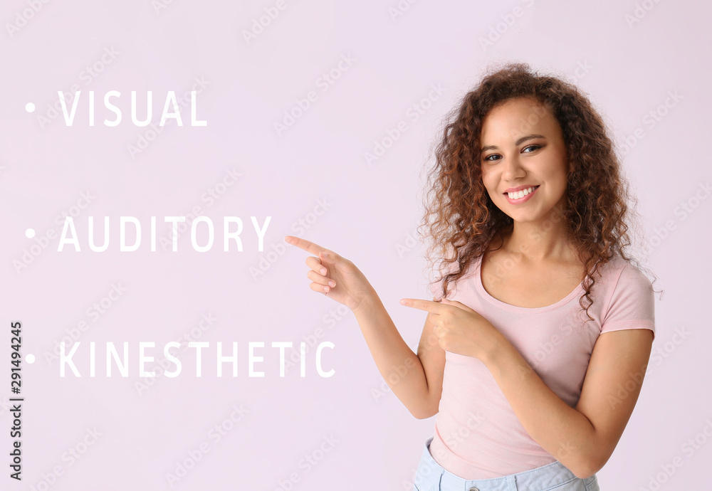 Beautiful African-American woman pointing at something on white ...
