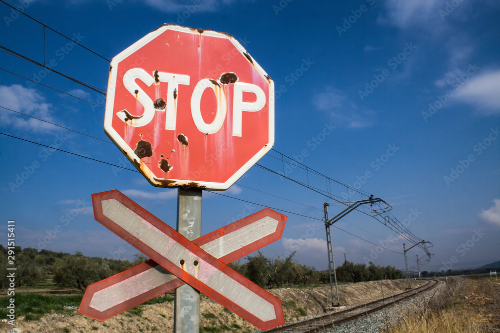 Warning sign worn of level crossing without barriers, blue sky with ...