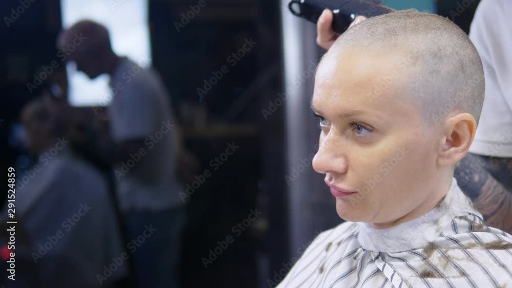 concept of hair loss after chemotherapy. the hairdresser shaves the ...