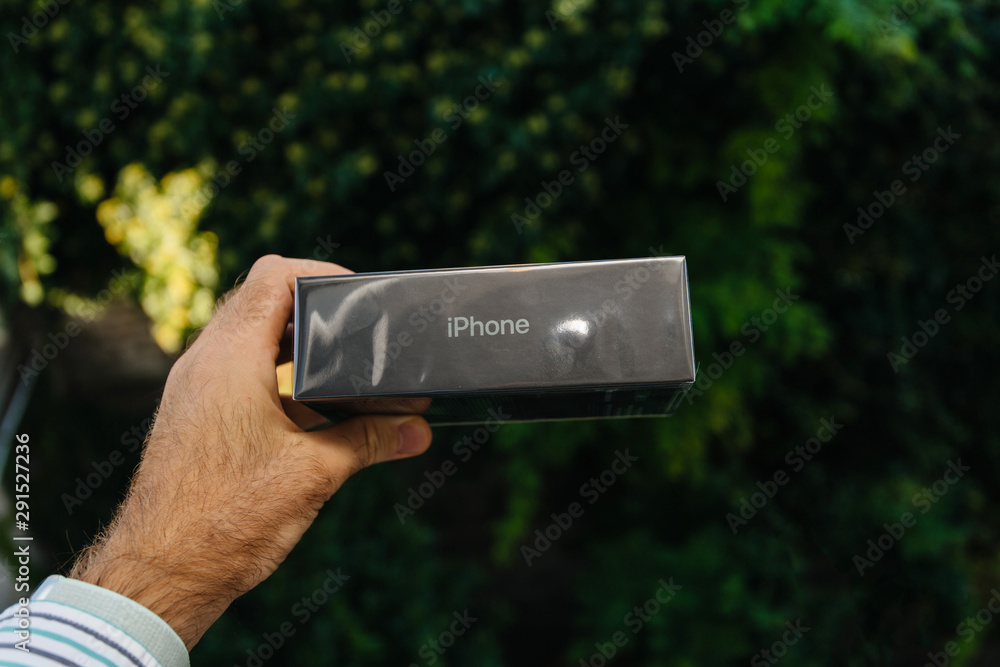 Paris, France - Sep 20, 2019: Man hand holding side cardboard box with ...